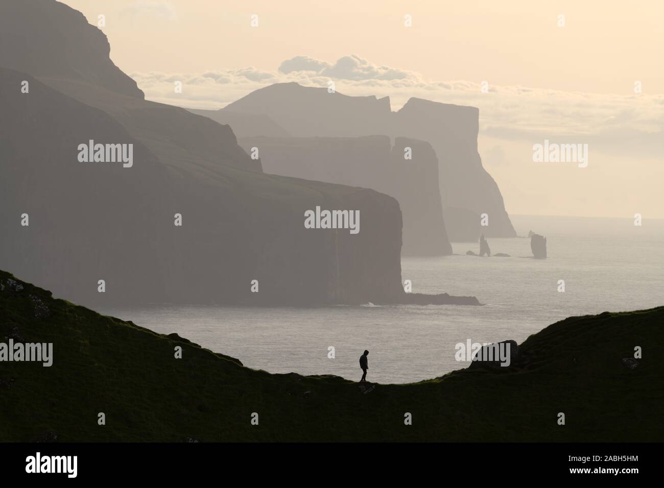 Man silhouette on background of famous Risin og Kellingin rocks and ...