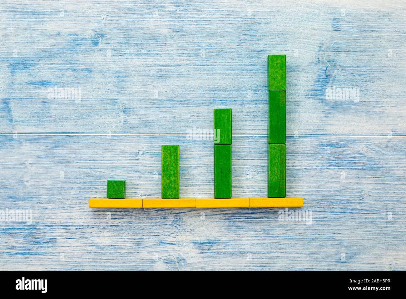 Bar graph showing growth made of building blocks on blue wooden ...