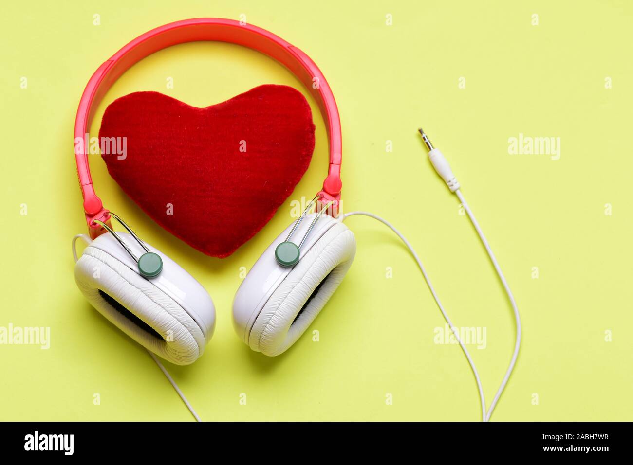 Headphones in white and red color with soft toy heart. Modern and ...