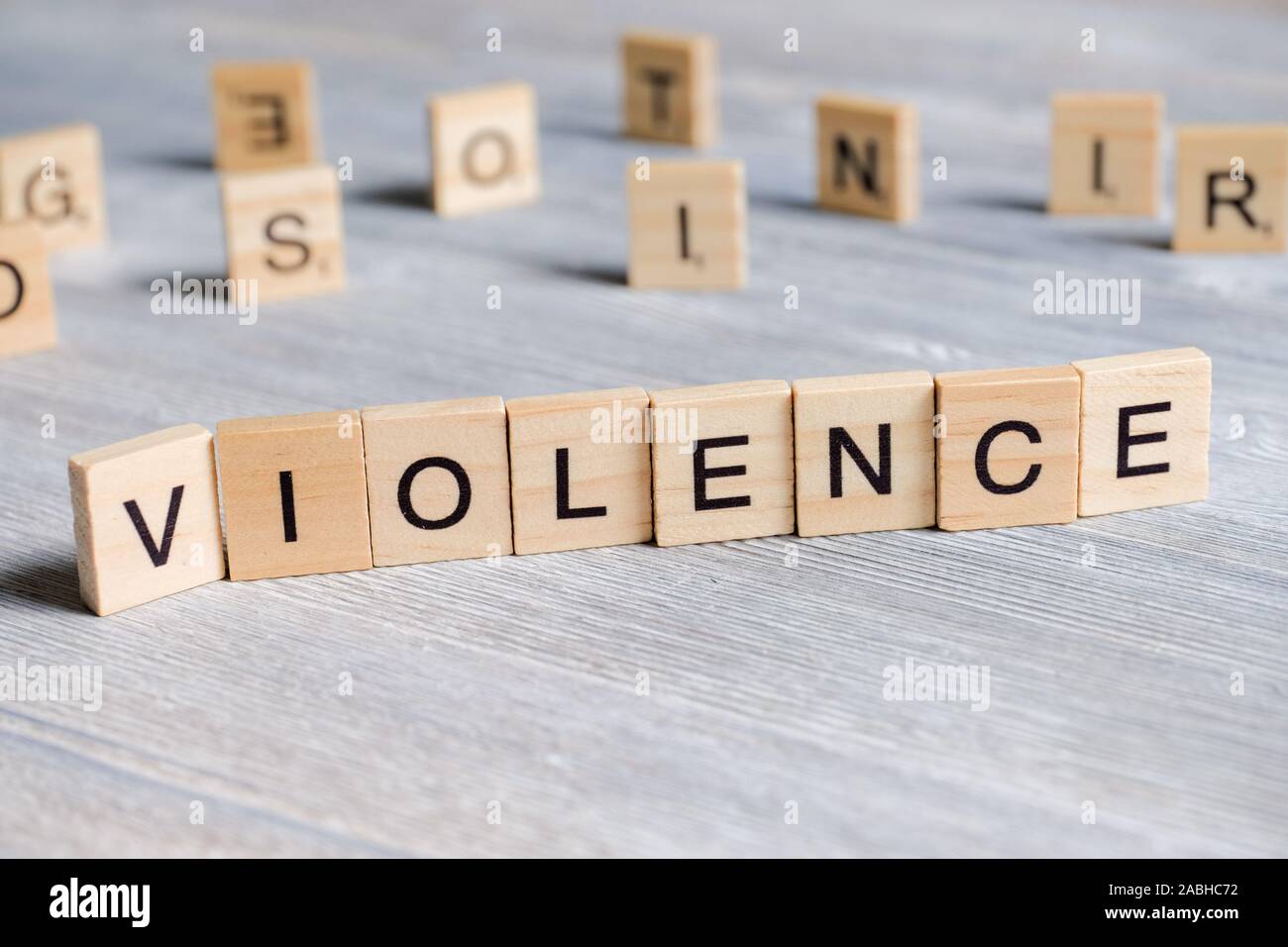 Word made of wooden letters - violence, on a gray background with cubes ...