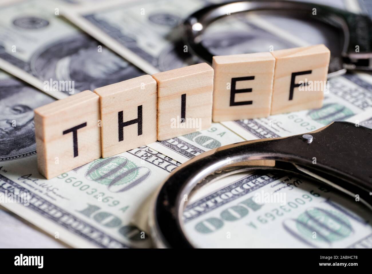 Word made of wooden letters - thief, on a gray background with us ...