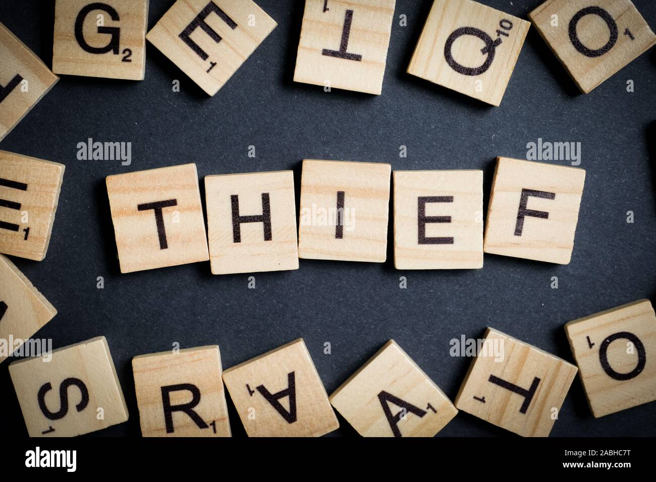 Word made of wooden letters - thief, on black. Crime designation ...
