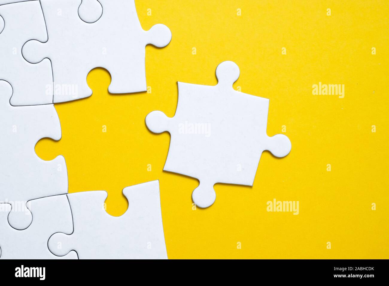 Final white piece is lying next to the jigsaw puzzle on yellow ...