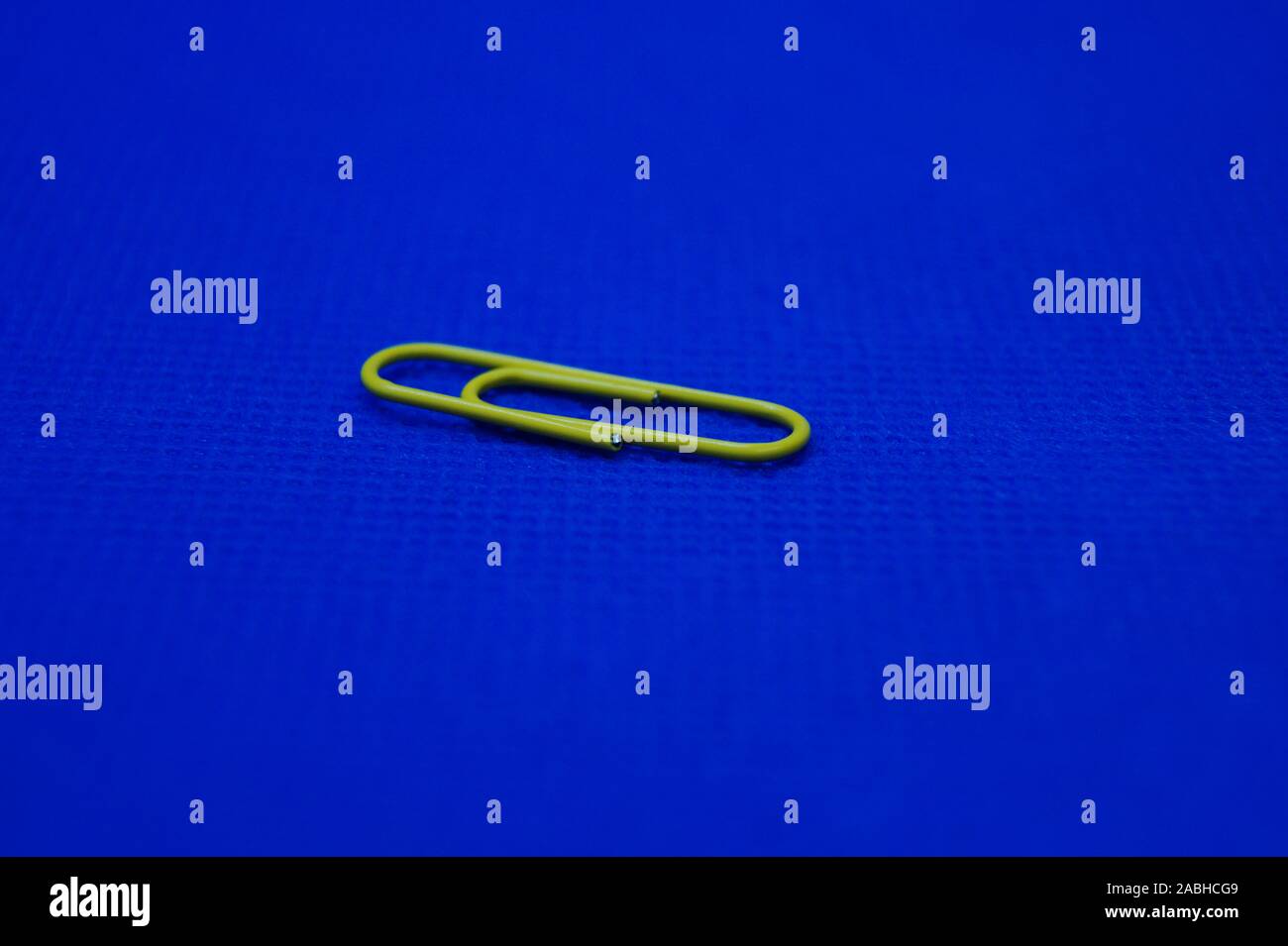 Colorful paperclip with a blue background Stock Photo - Alamy