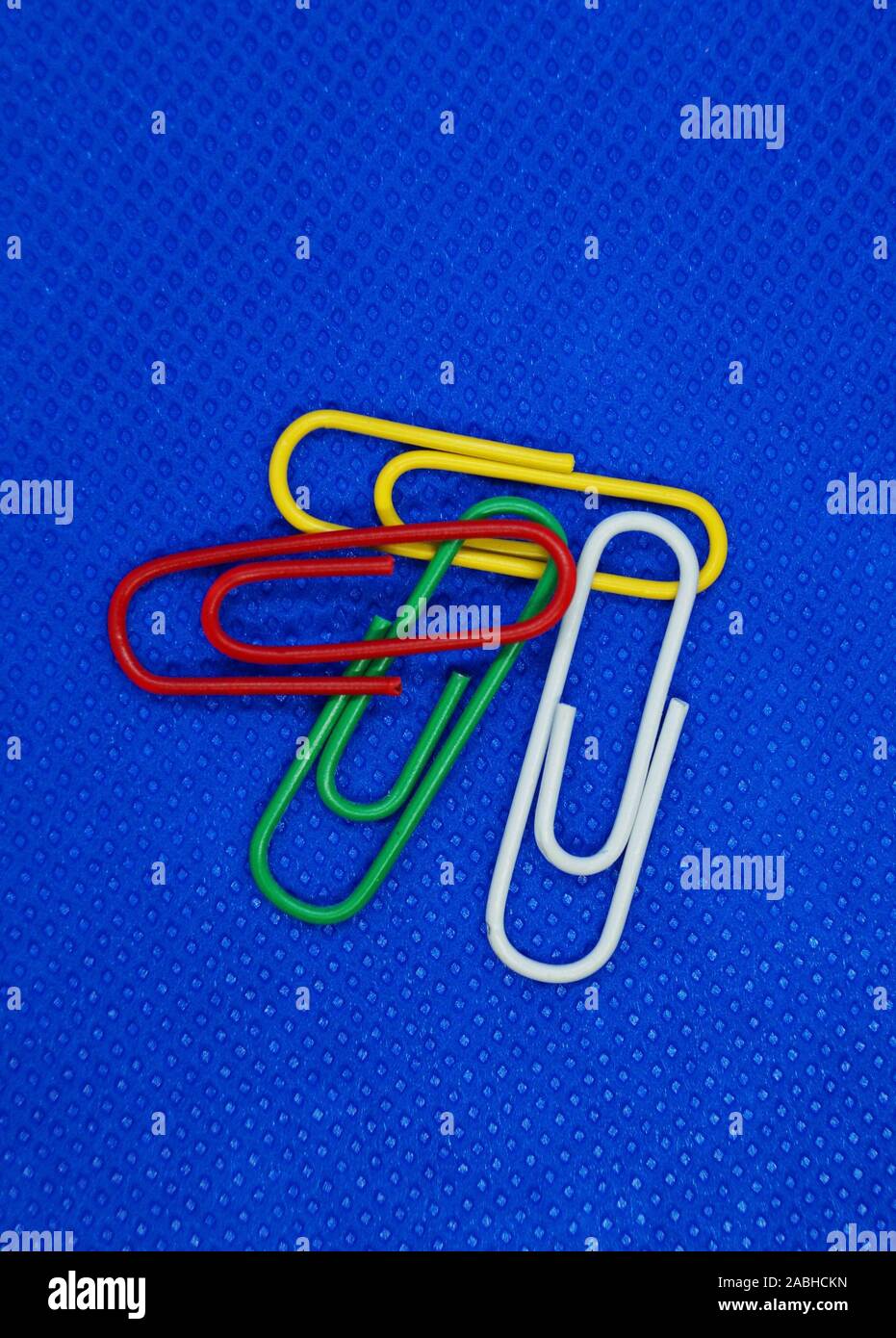 Colorful paperclip with a blue background Stock Photo - Alamy