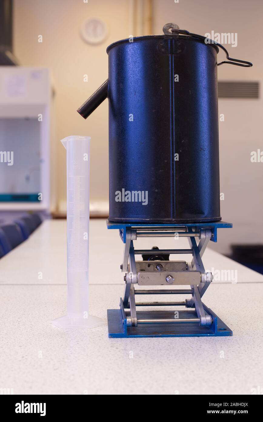 Spouting can with measuring cylinder of water to measure the density of ...