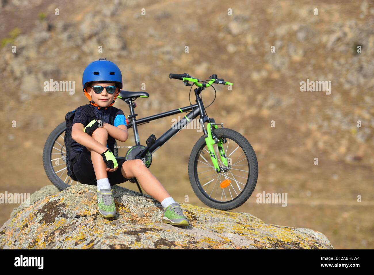 Happy kid boy of 7 years having fun in autumn park with a bicycle on ...