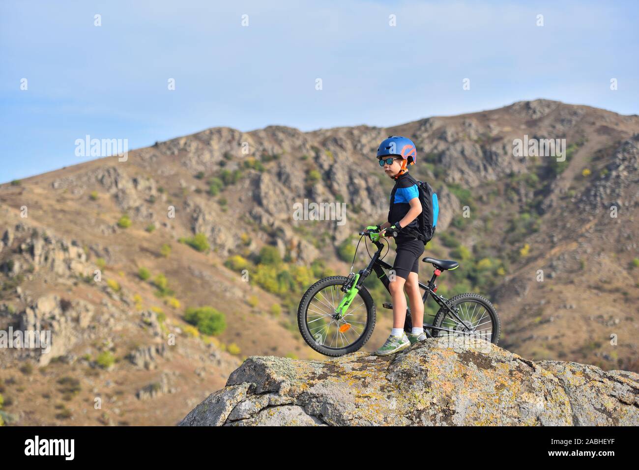 Happy kid boy of 7 years having fun in autumn park with a bicycle on ...