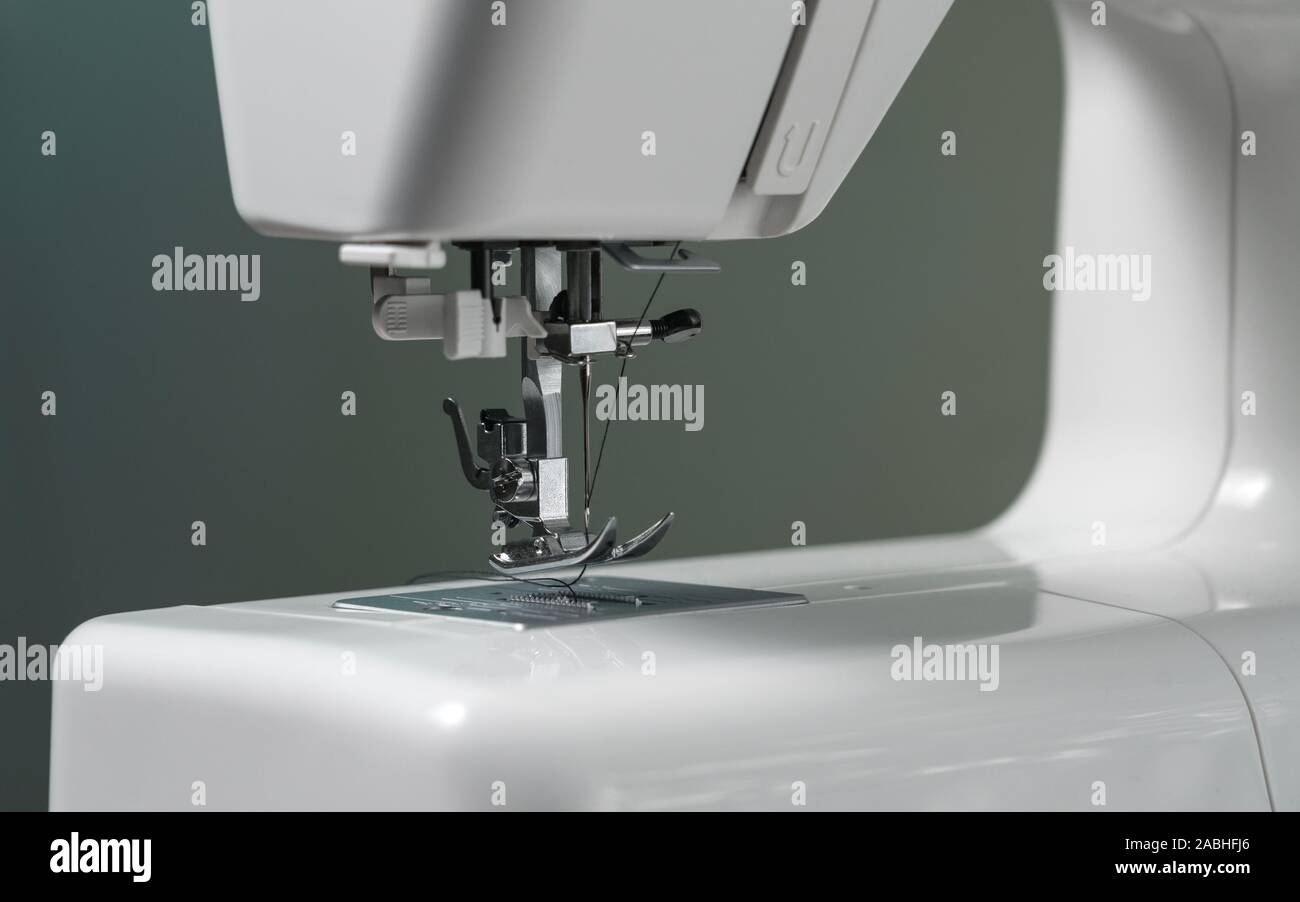White Sewing machine needle mechanism close up on green background ...