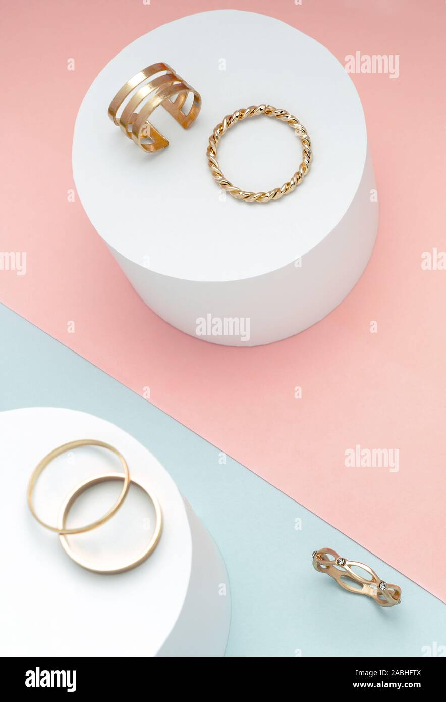 Top view of golden rings set on pink and green background Stock Photo ...