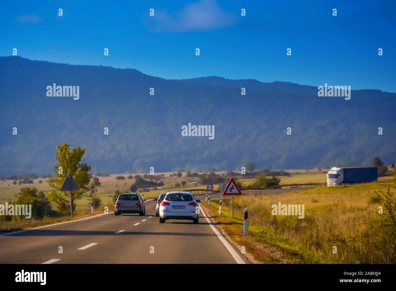 A car overtaking line of cars while a truck is coming from the opposite ...