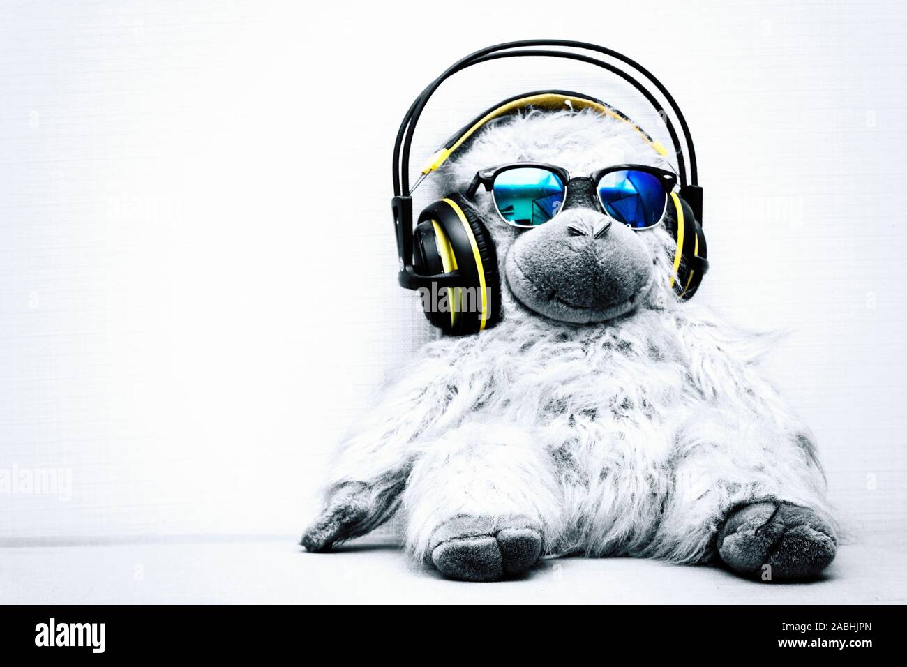 Concept of a dance monkey listening to music on headphones and wearing ...