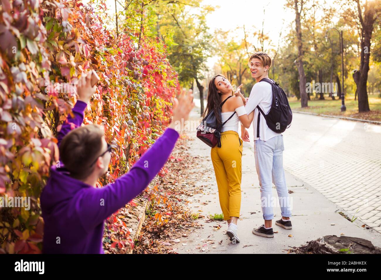 Happy young couple greeting and waving their friend on the street Stock ...
