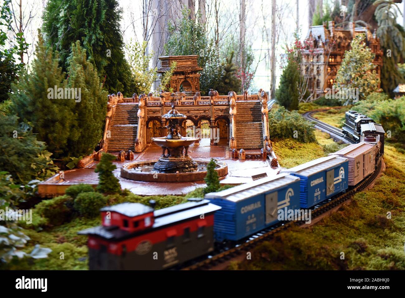 New York, USA. 26th Nov, 2019. A model train runs past miniature ...