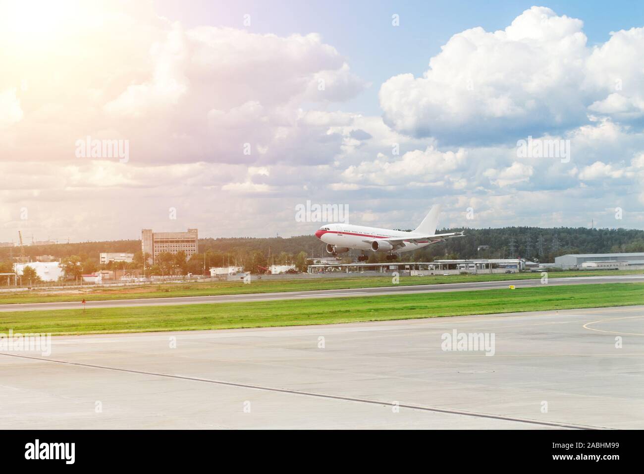Airplane taking off from the airport. white with red stripe passenger ...