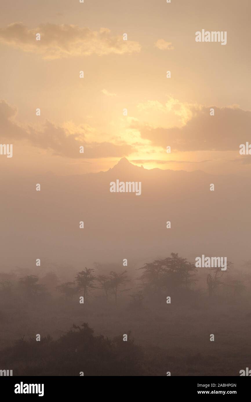 view of Mount Kenya, at sunrise from a distance with clouds above ...