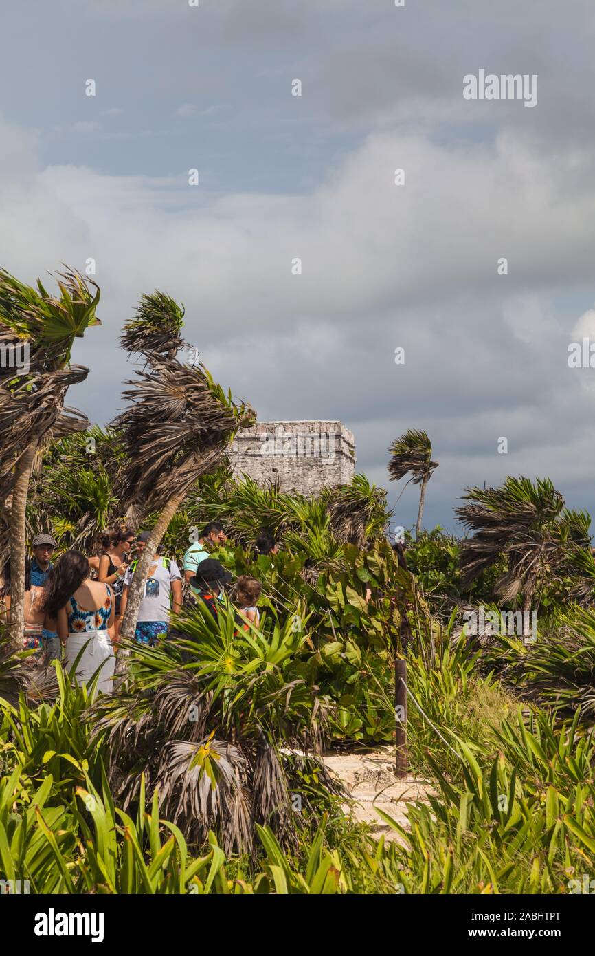 Tourists walking along the clifftop trail at the Tulum Mayan ruins site ...