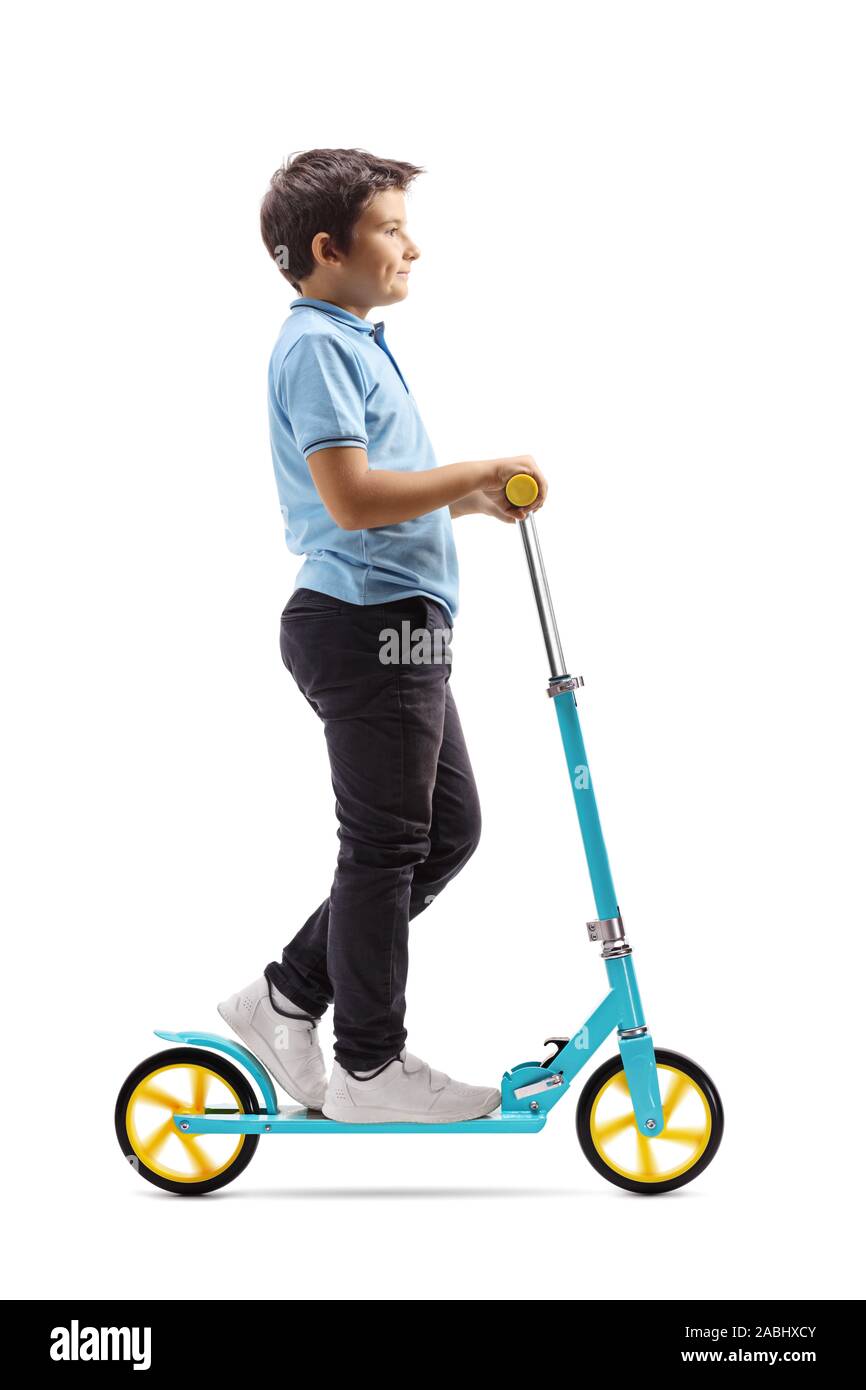 Full length profile shot of a boy riding a scooter isolated on white ...