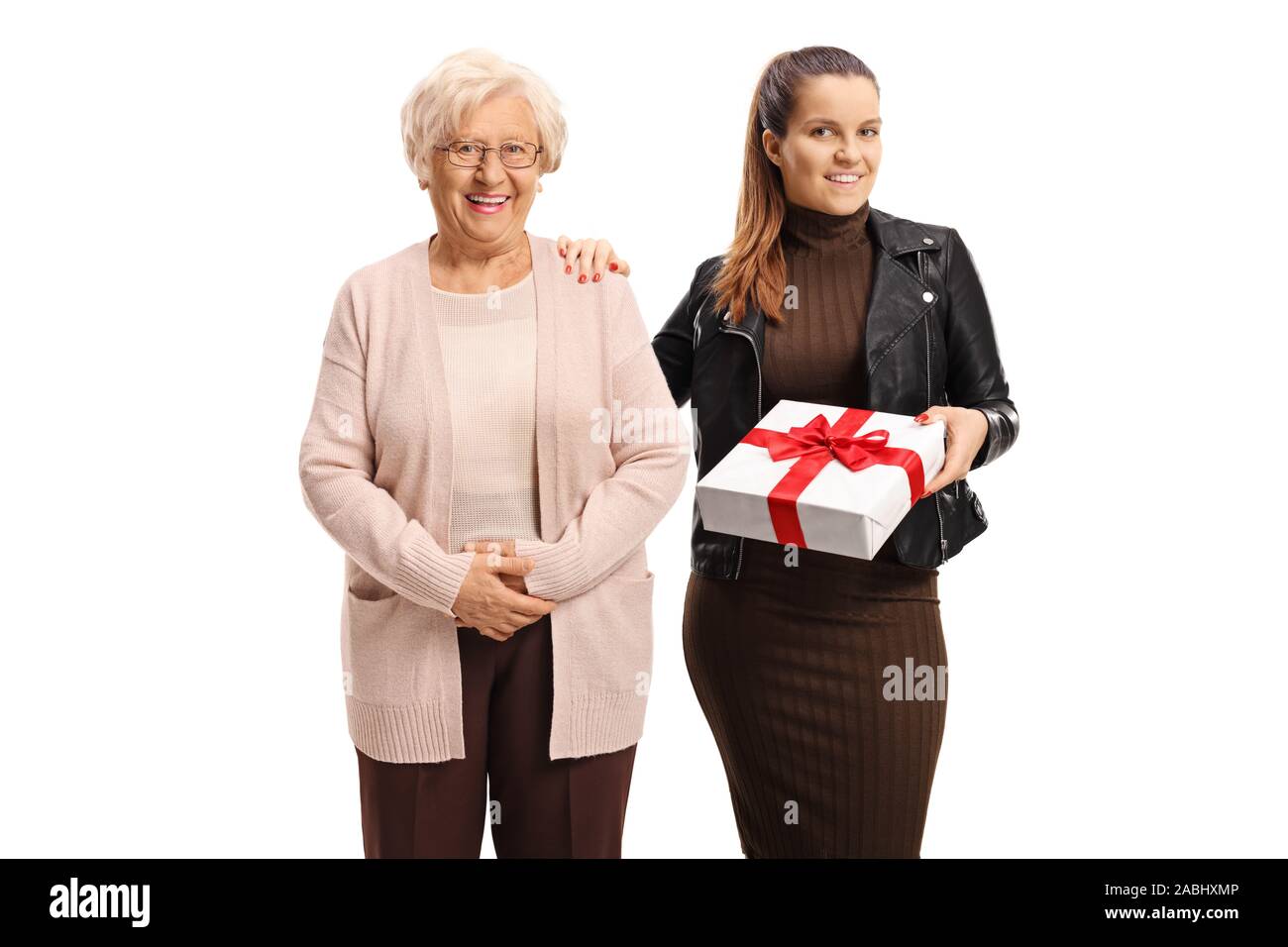 Young woman holding a present and posing next to an older lady isolated ...
