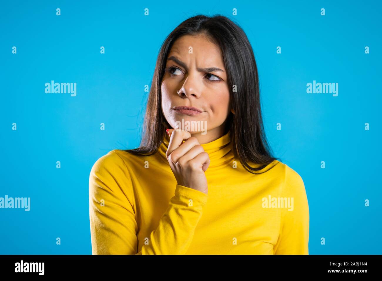 Thinking woman looking around on blue background. Worried contemplative ...