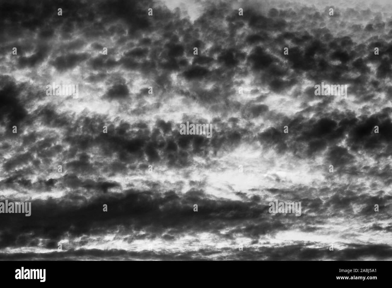 Altocumulus Perlucidus clouds toward sunset in dramatic sky, black and ...