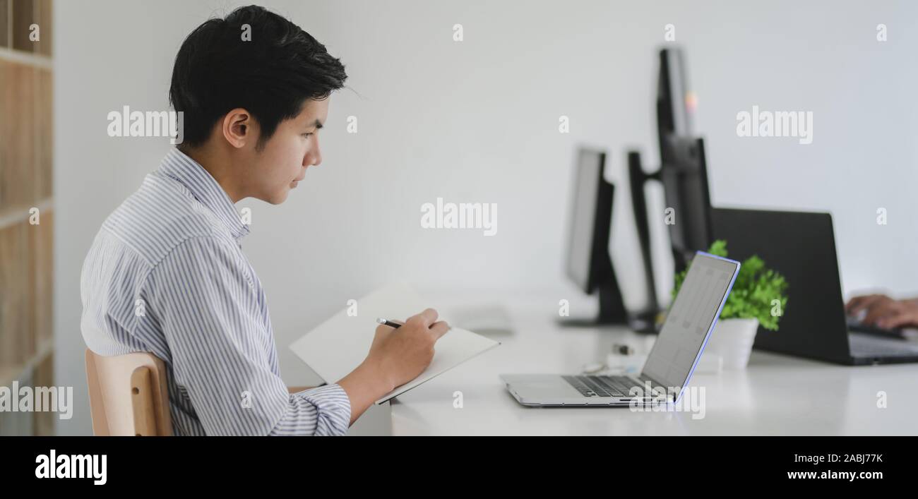 Young professional UI web developer working on his project with laptop ...