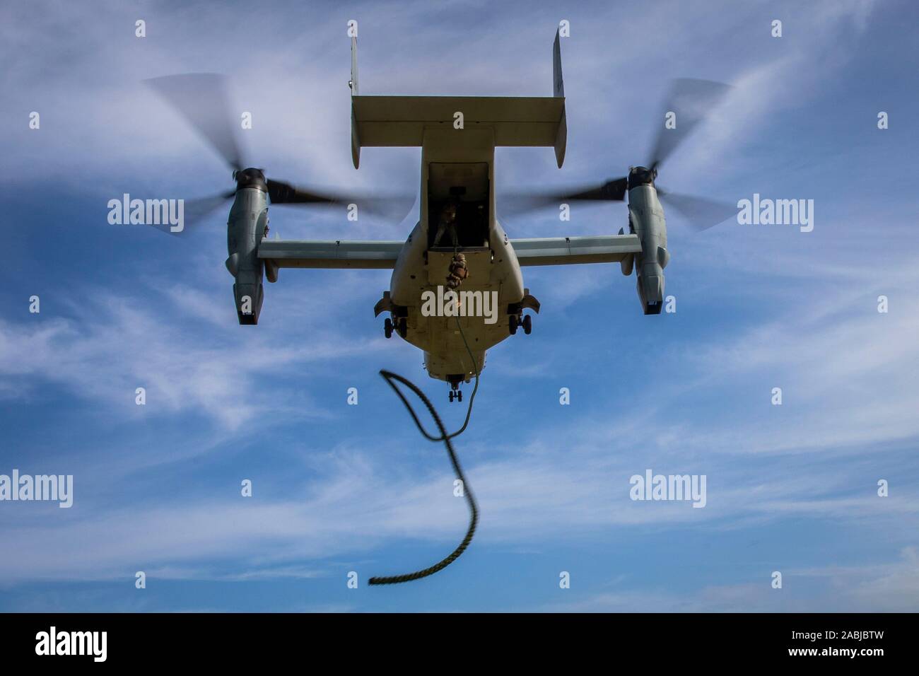 A U.S. Marine with 2nd Battalion, 3d Marine Regiment, fast ropes from a ...
