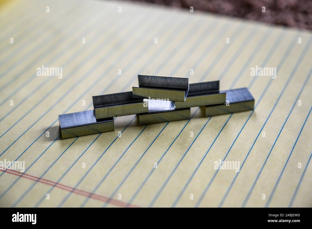 pyrimidine stack of stapler refill clips on lined paper pad Stock Photo ...