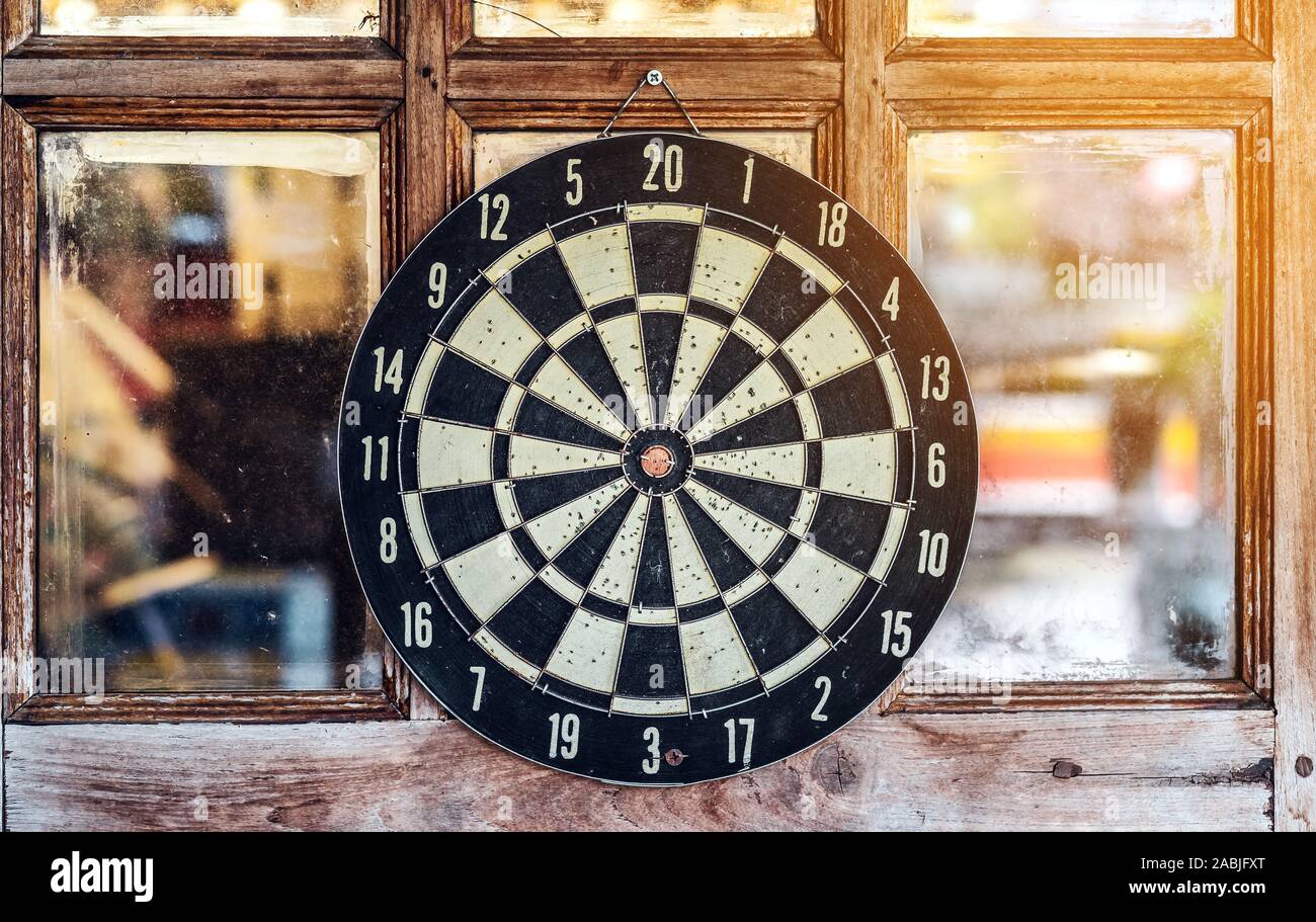 An old darts target hanging on old glass and wooden door Stock Photo ...