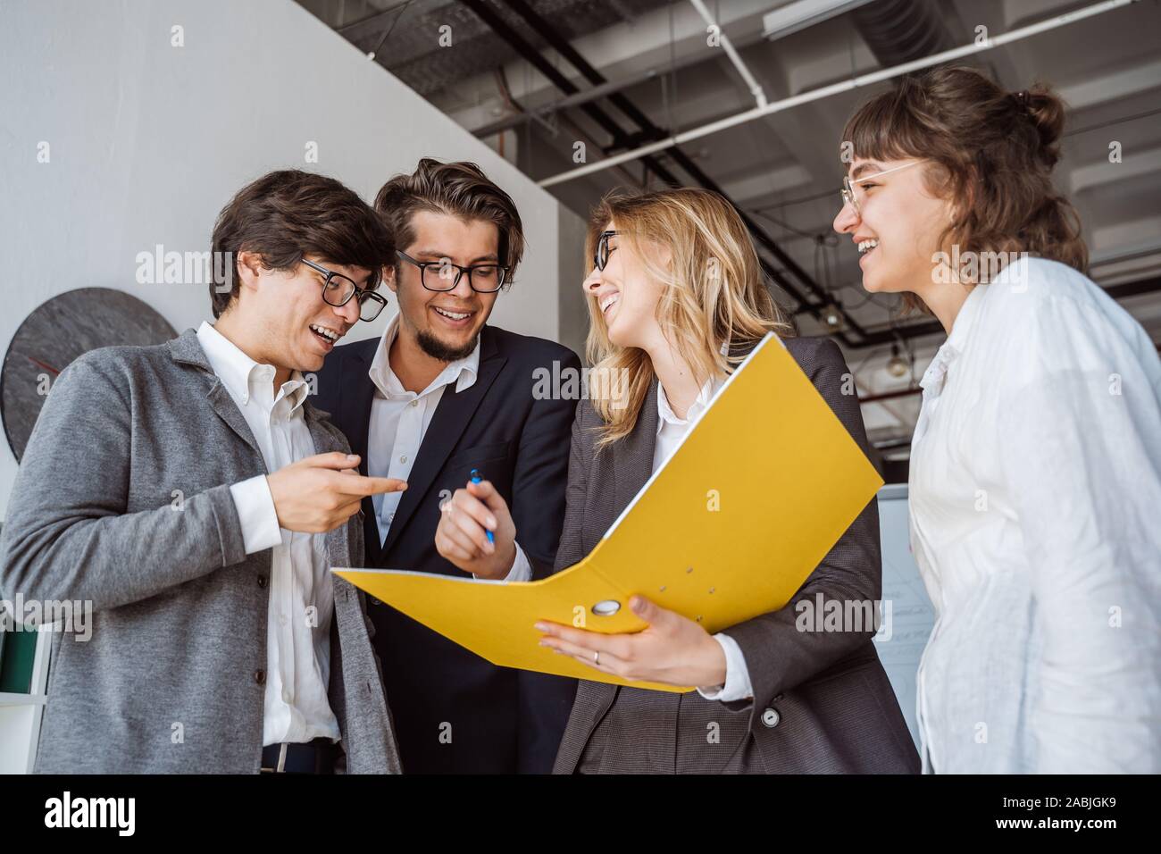 Group of inspired young people standing and discussing new project ...