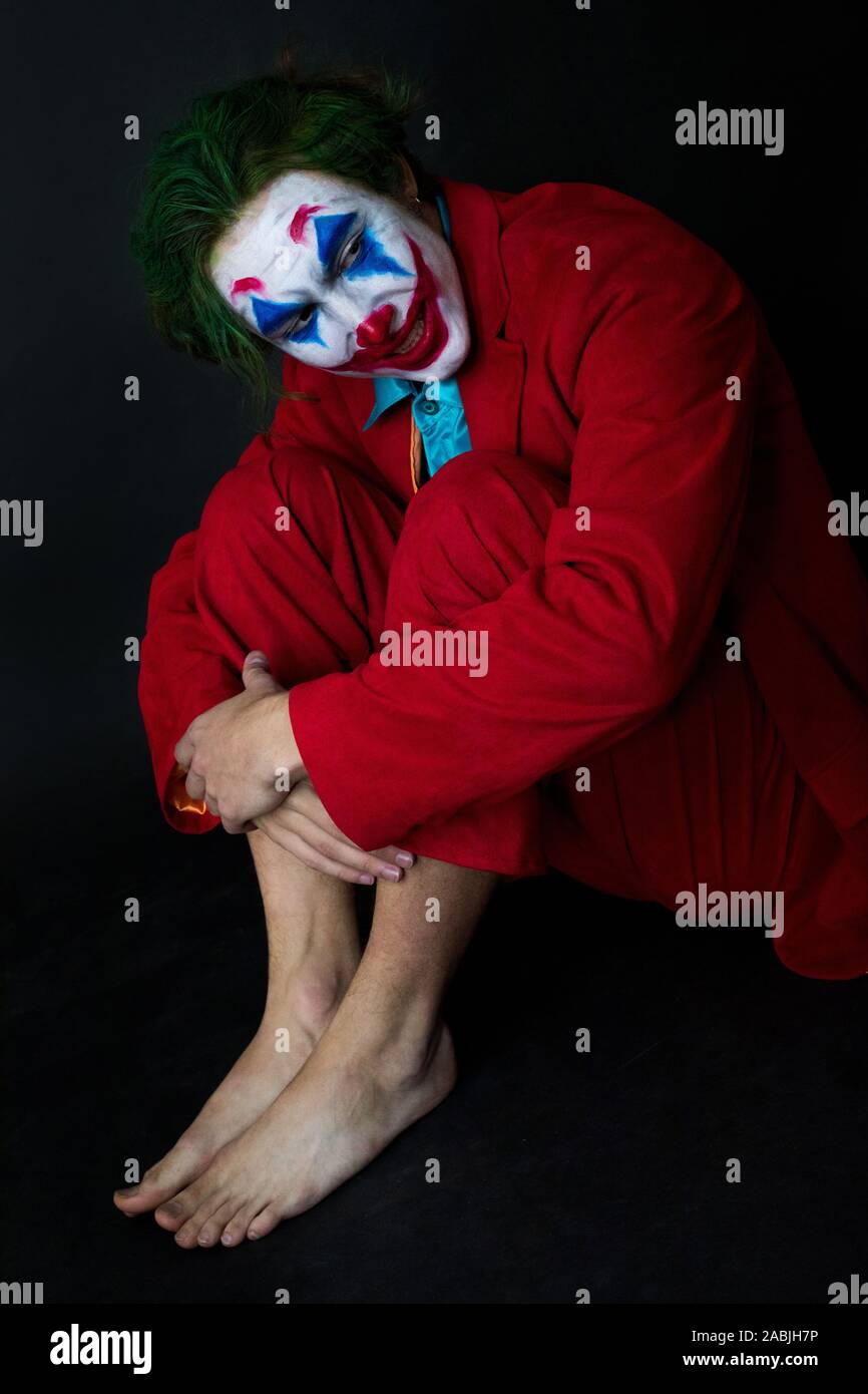 Man impersonating the Joker. Portrait of a man in a suit with clown ...