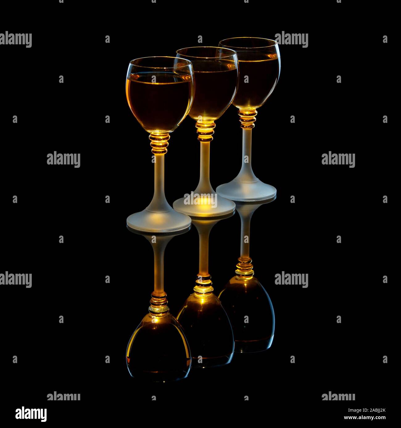Three shot glasses with rum, jager or cognac alcohol on a black ...