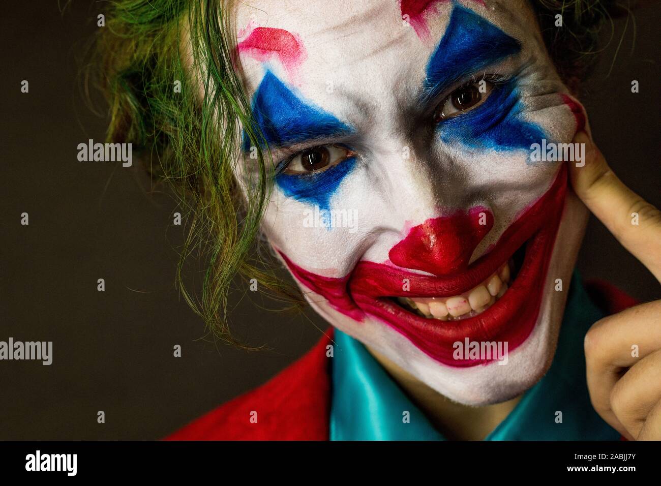 Man impersonating the Joker. Portrait of a smiling man with clown ...