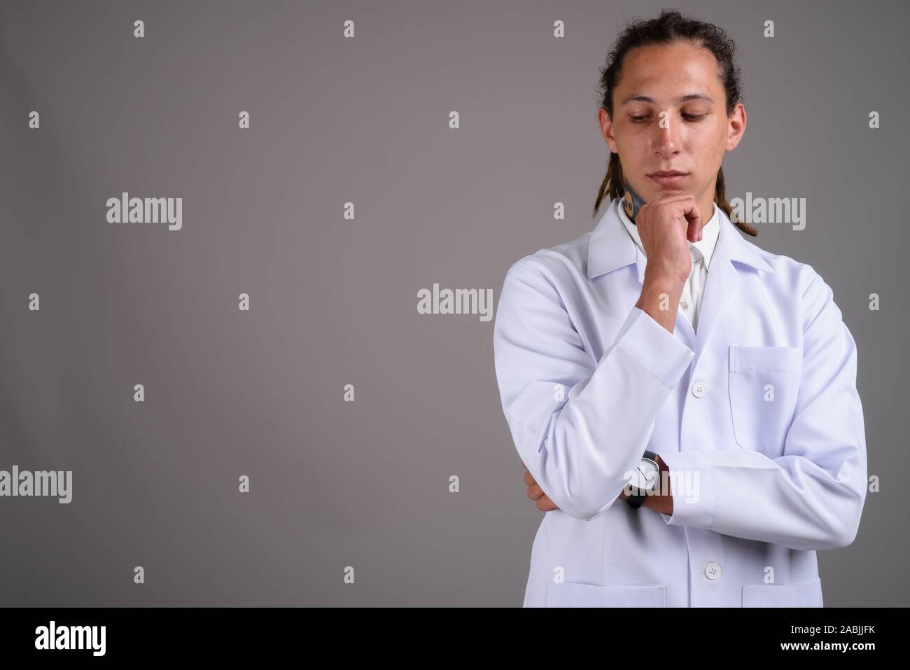 Young man doctor with dreadlocks against gray background Stock Photo ...