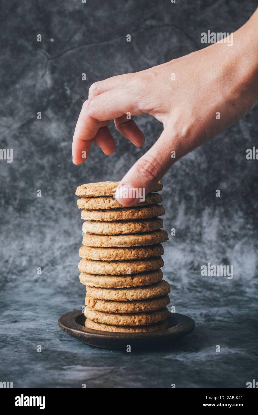 Hand trying to take a cookie Stock Photo - Alamy