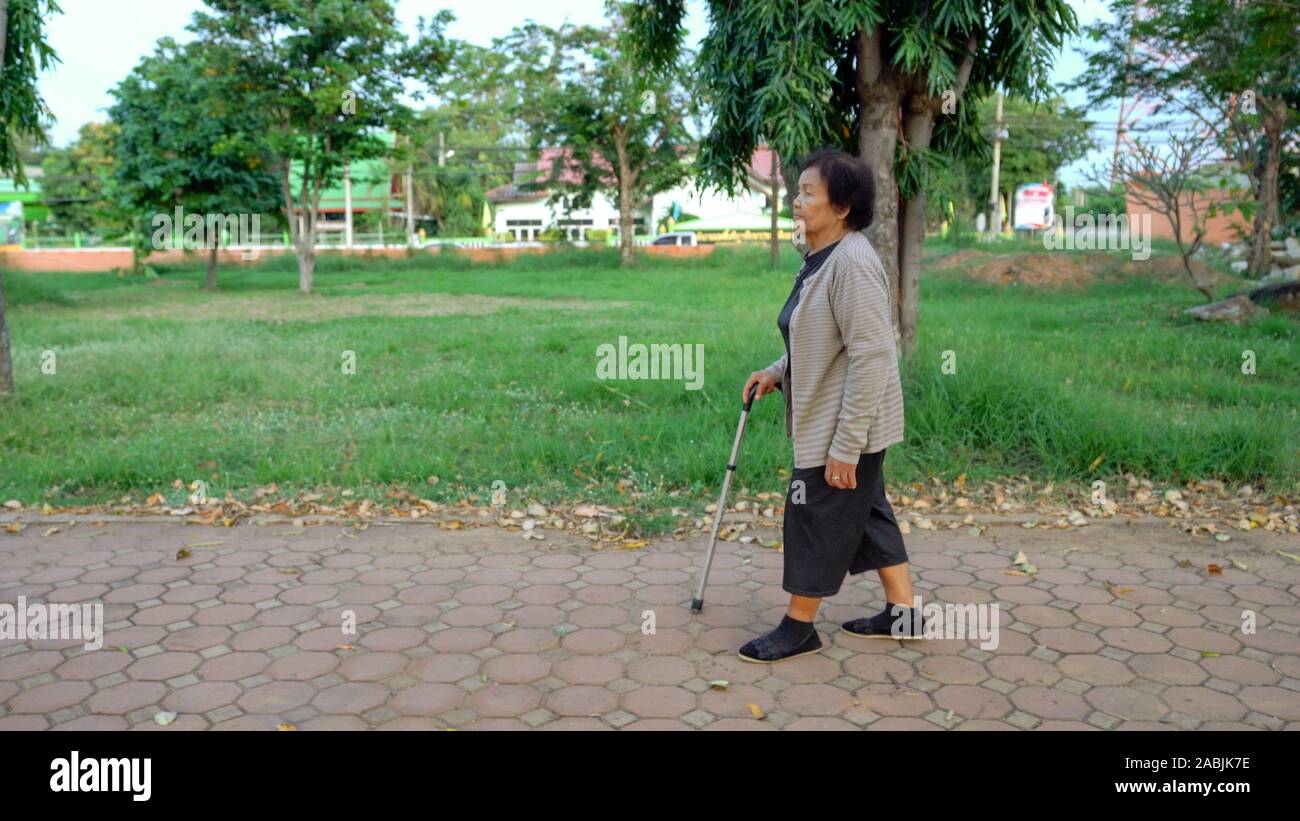 Older woman with walking stick hi-res stock photography and images - Alamy