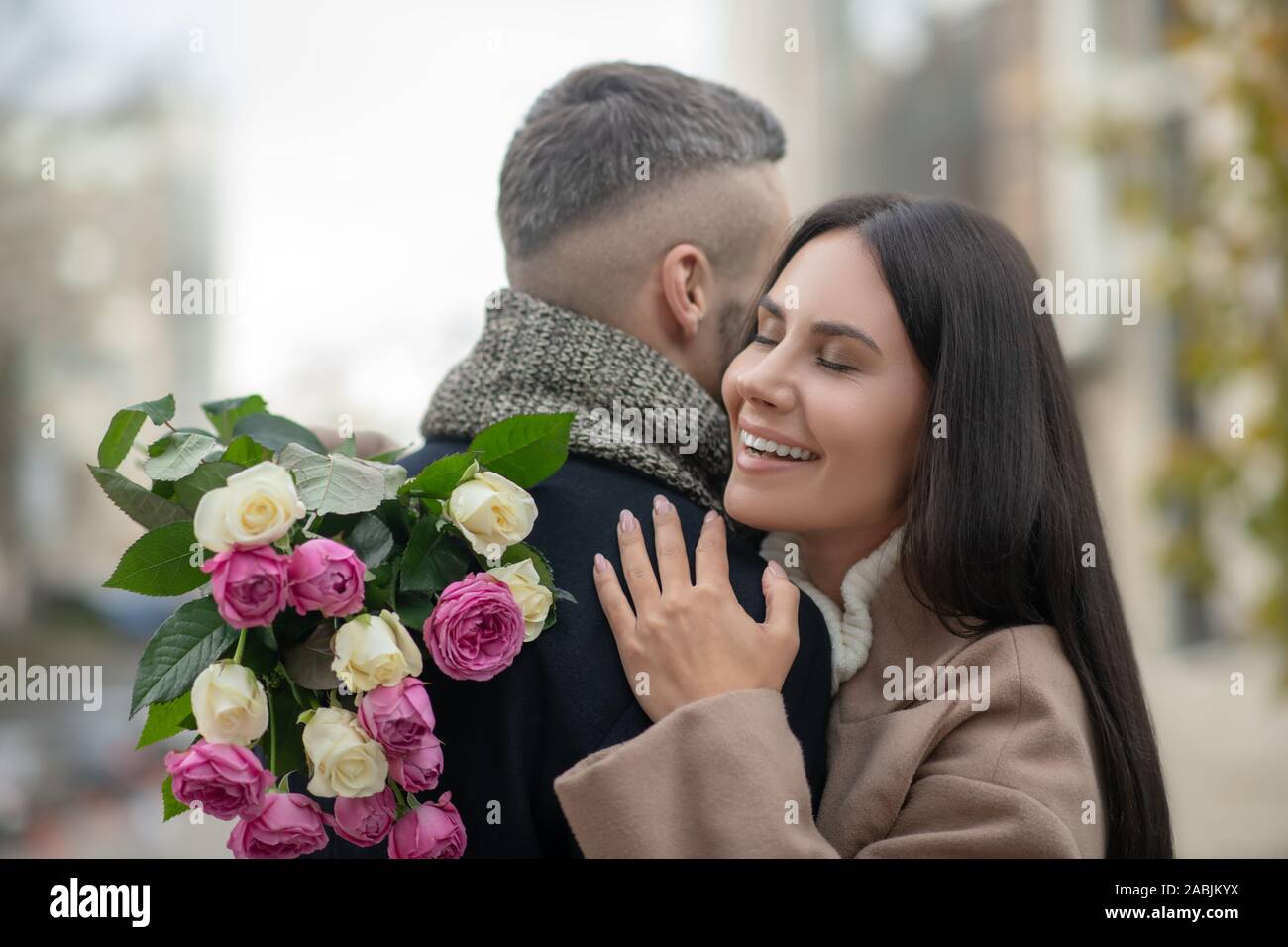 Happy nice young woman hugging her husband Stock Photo - Alamy