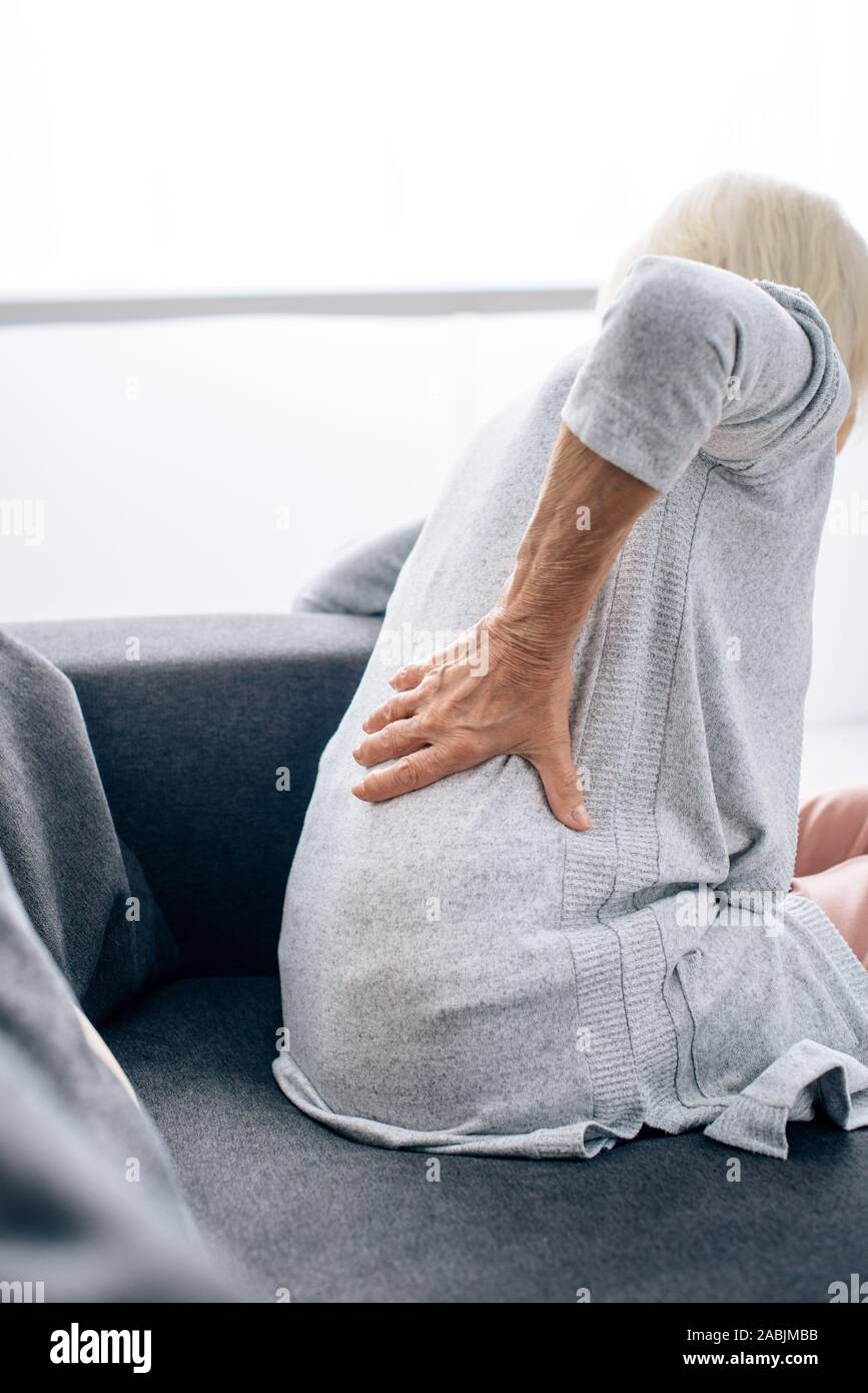 back view of senior woman having back pain in apartment Stock Photo - Alamy