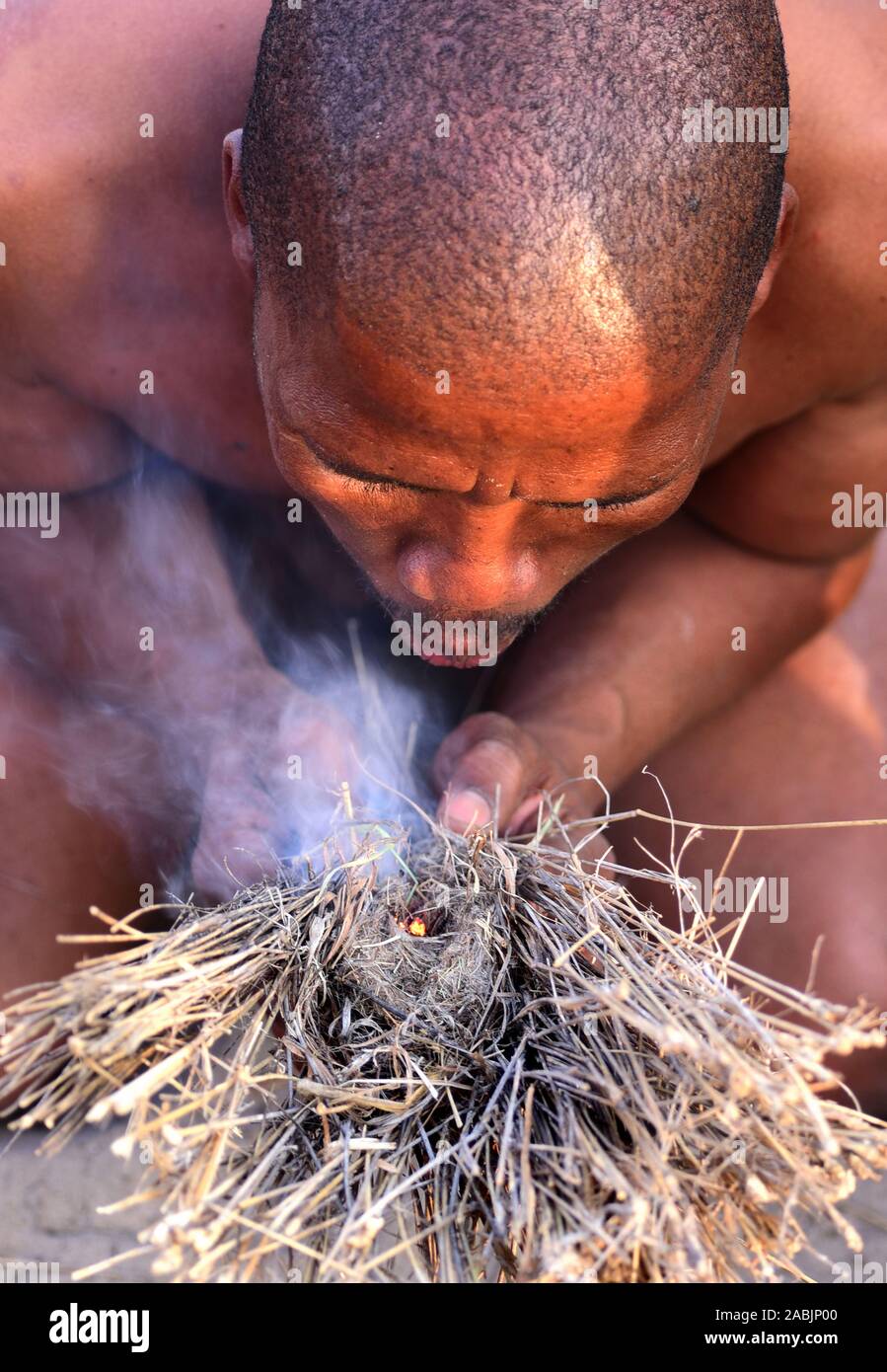 Close up of a bushman making fire in the Kalahari desert. Botswana ...