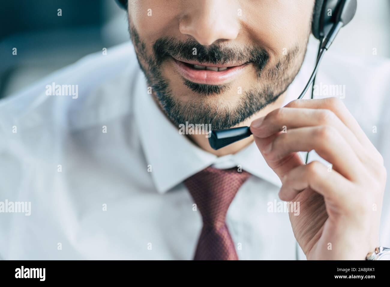partial view of smiling call center operator using headset Stock Photo - Alamy