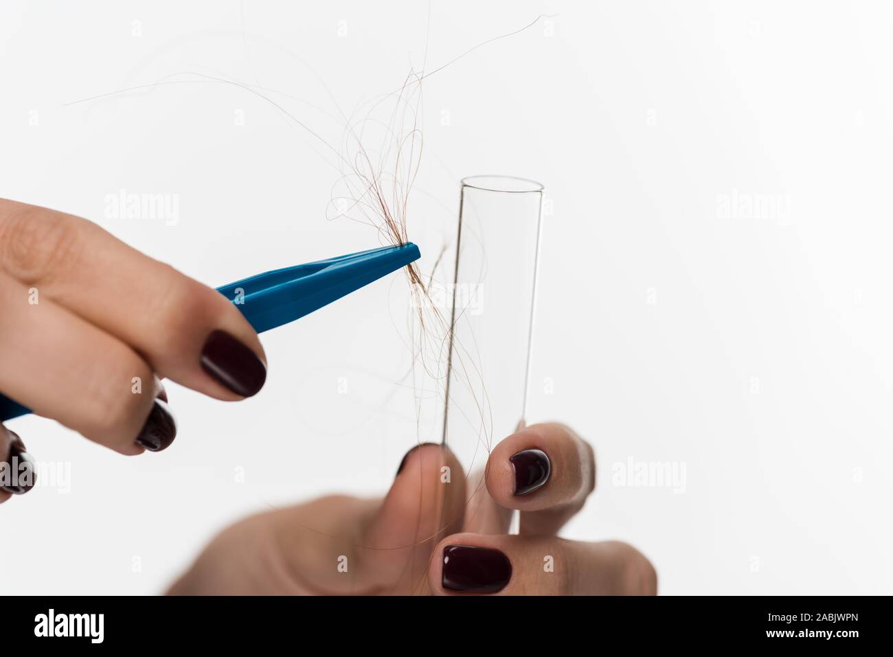 cropped view of woman holding hair sample near test tube isolated on ...