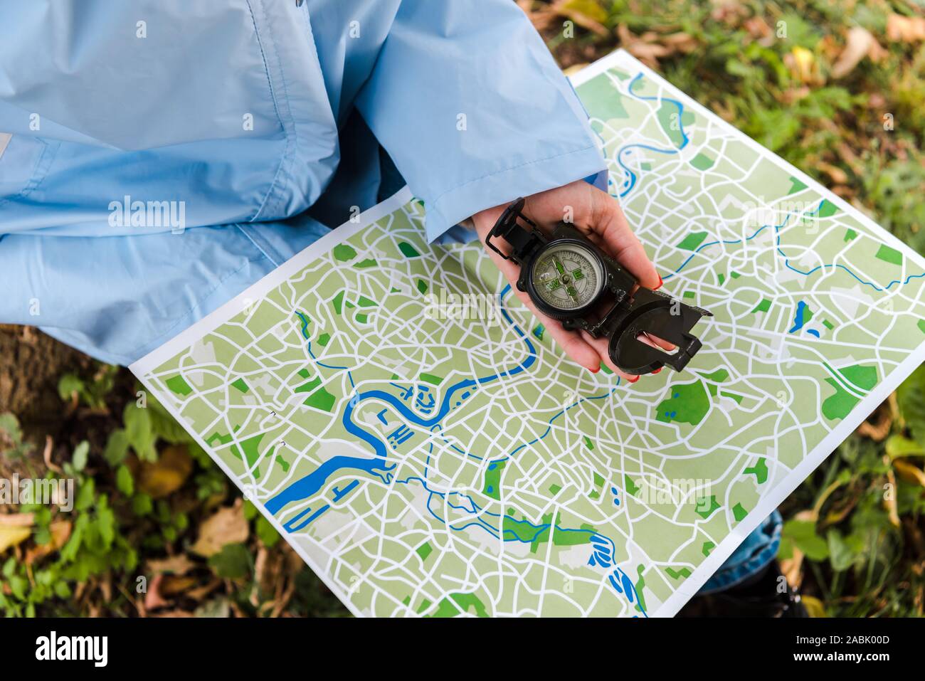 cropped view of traveler holding map and compass outside Stock Photo ...