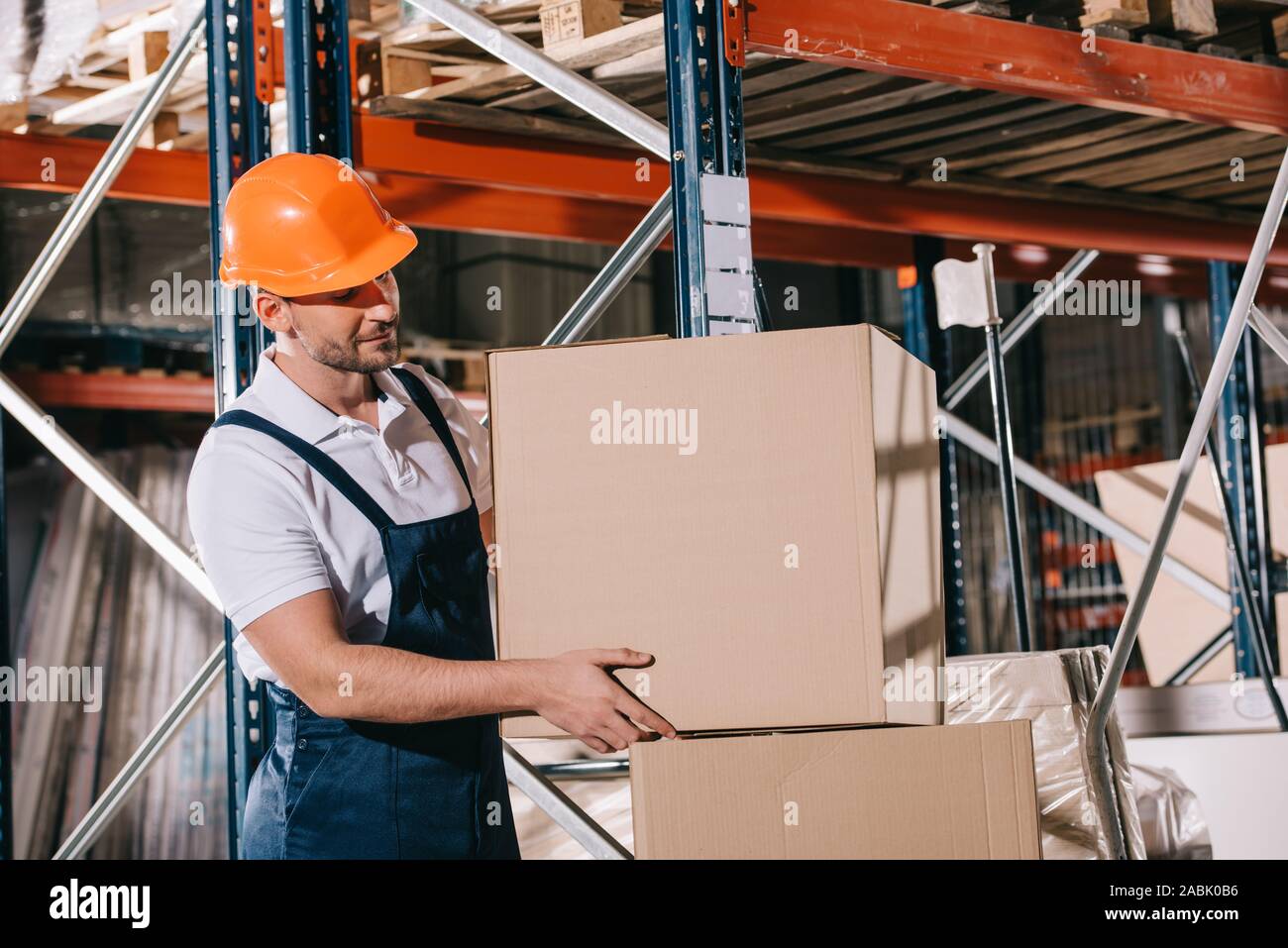 warehouse worker taking cardboard box from stack in warehouse Stock ...