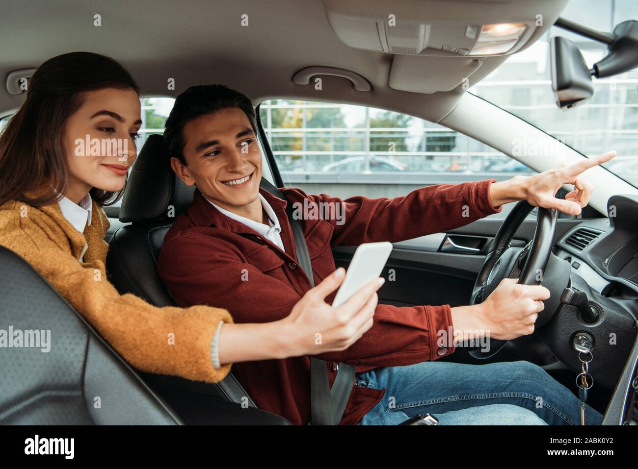 Woman passenger looking at smartphone while taxi driver pointing on ...