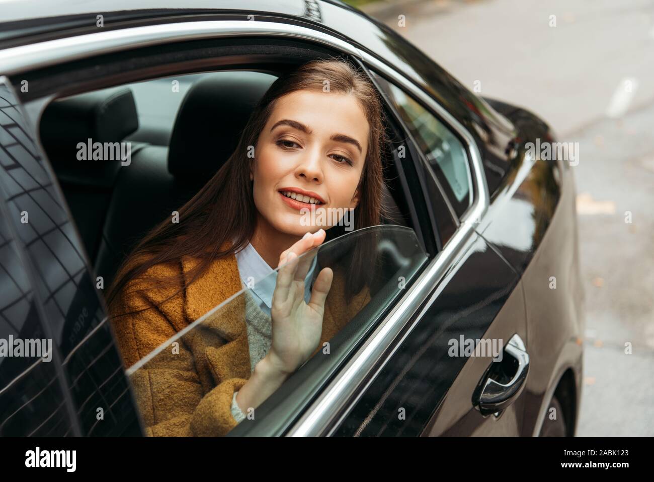 Young woman on back seat of taxi looking in window Stock Photo - Alamy