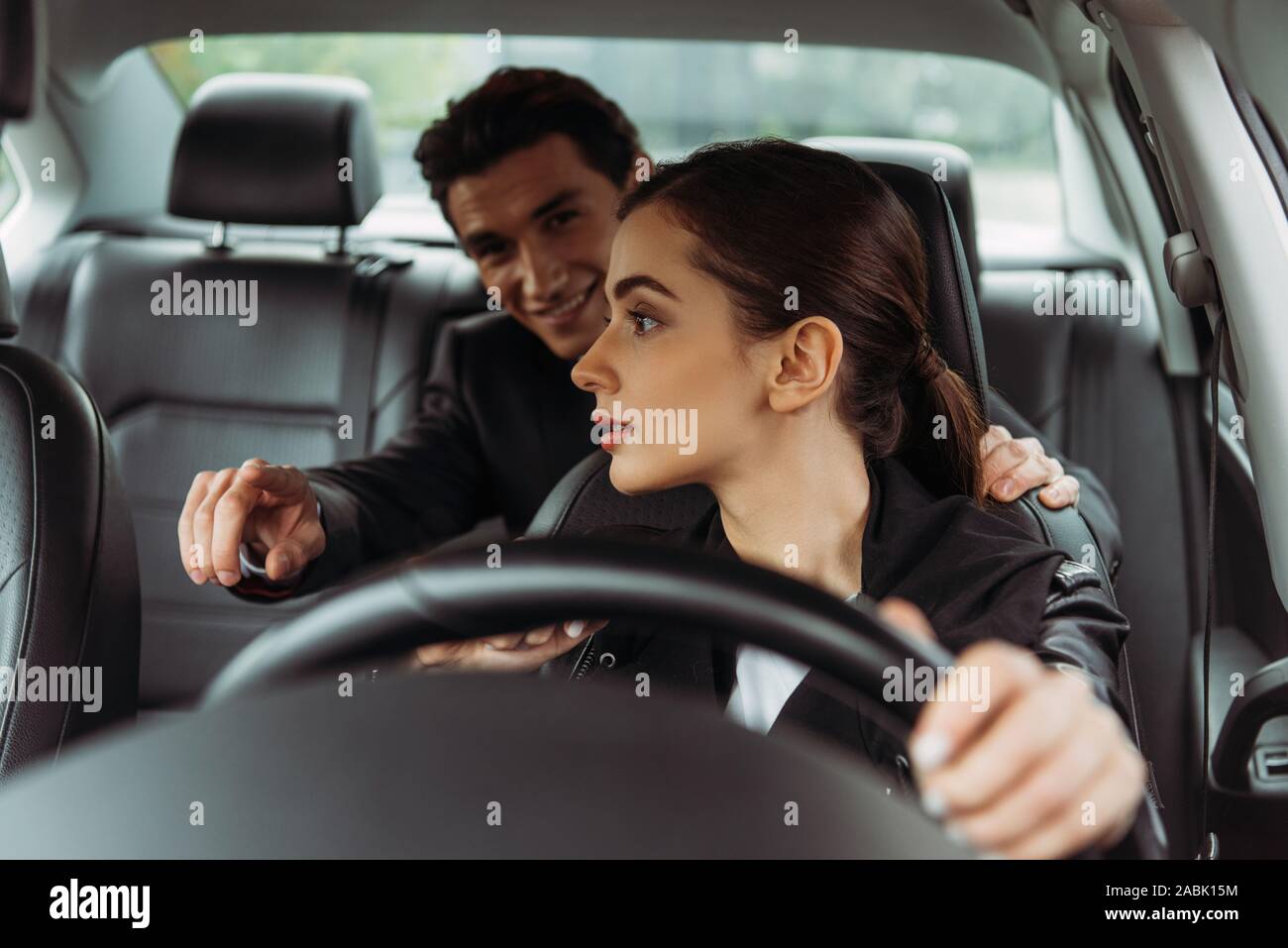 Businessman pointing on road to female taxi driver in car Stock Photo ...
