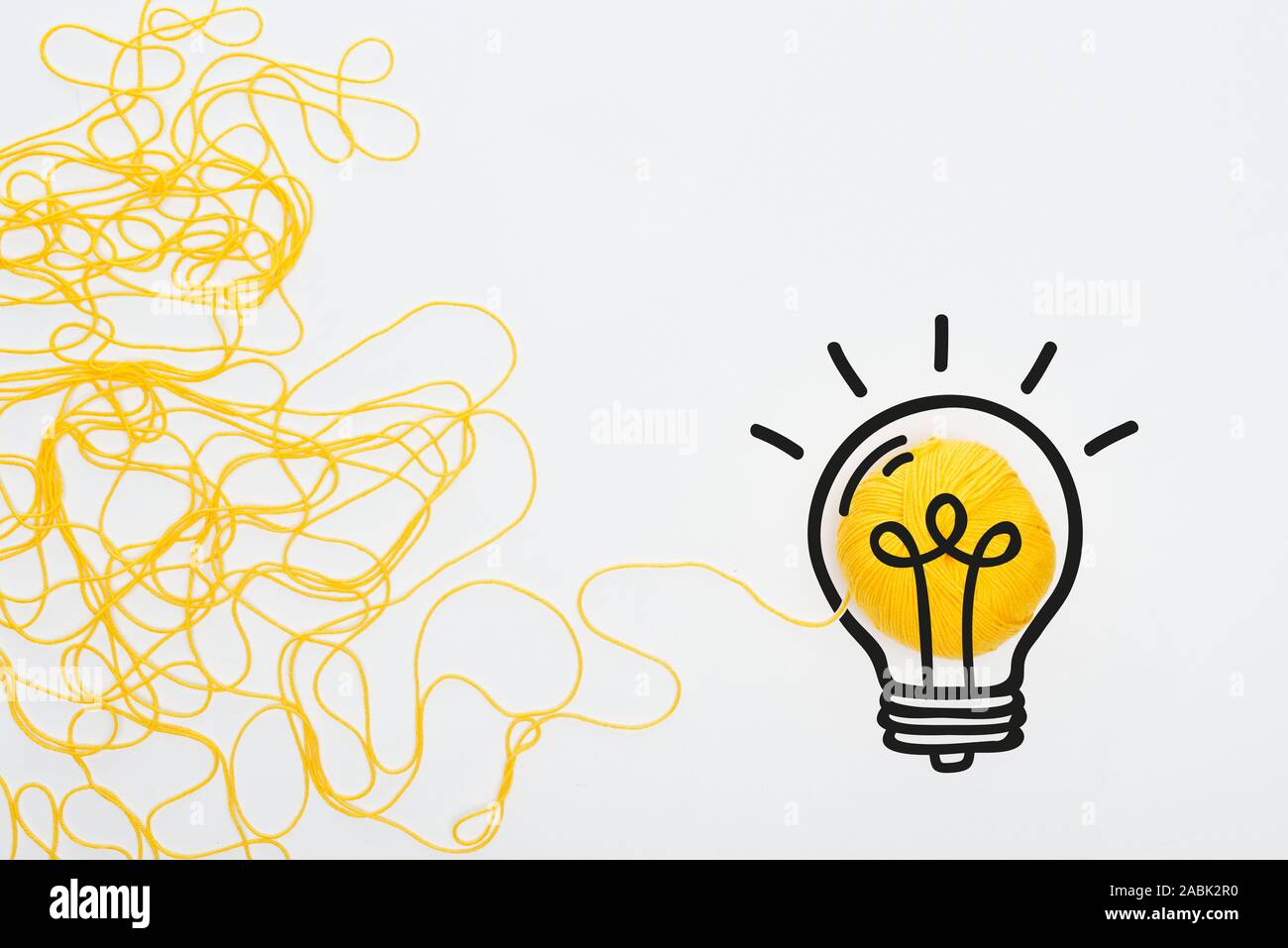 illustration of light bulb near yellow knitting ball and yarn on white ...