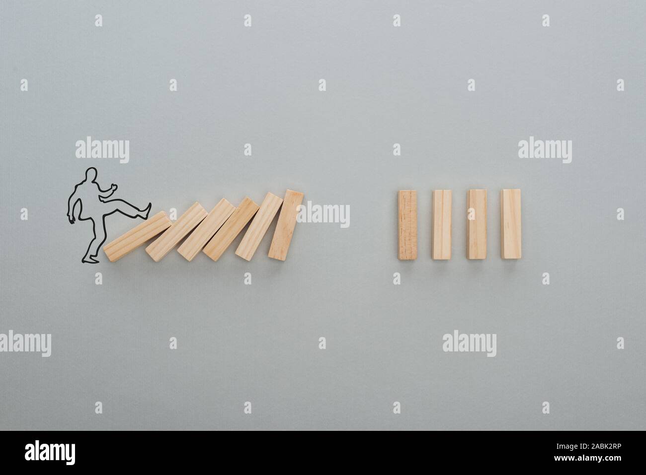 top view of drawn man pushing wooden blocks on grey background ...