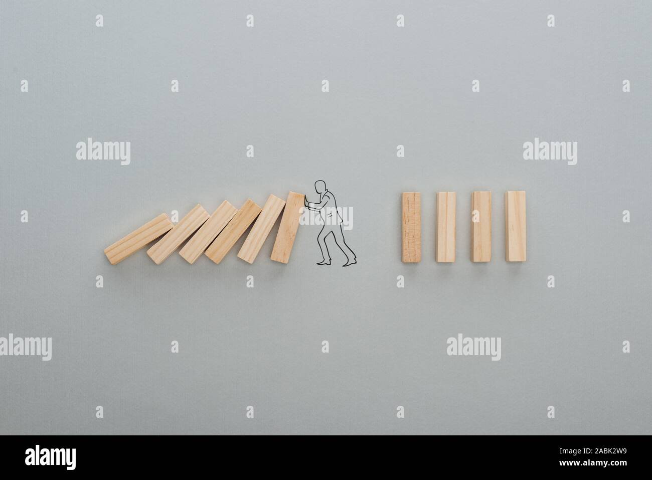 top view of drawn man pushing wooden blocks on grey background ...