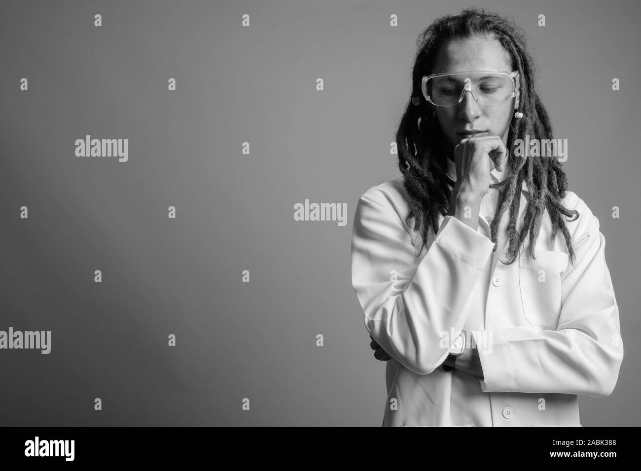 Young man doctor with dreadlocks wearing protective glasses in black ...